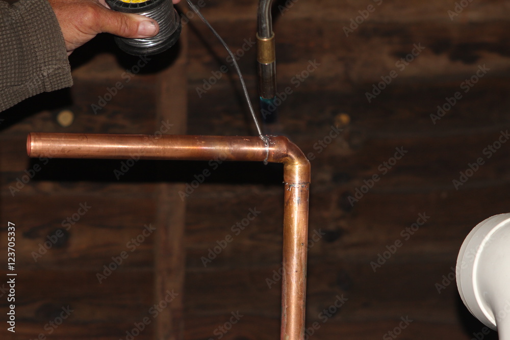 Plumber soldering a copper gas pipe to a boiler Stock Photo | Adobe Stock