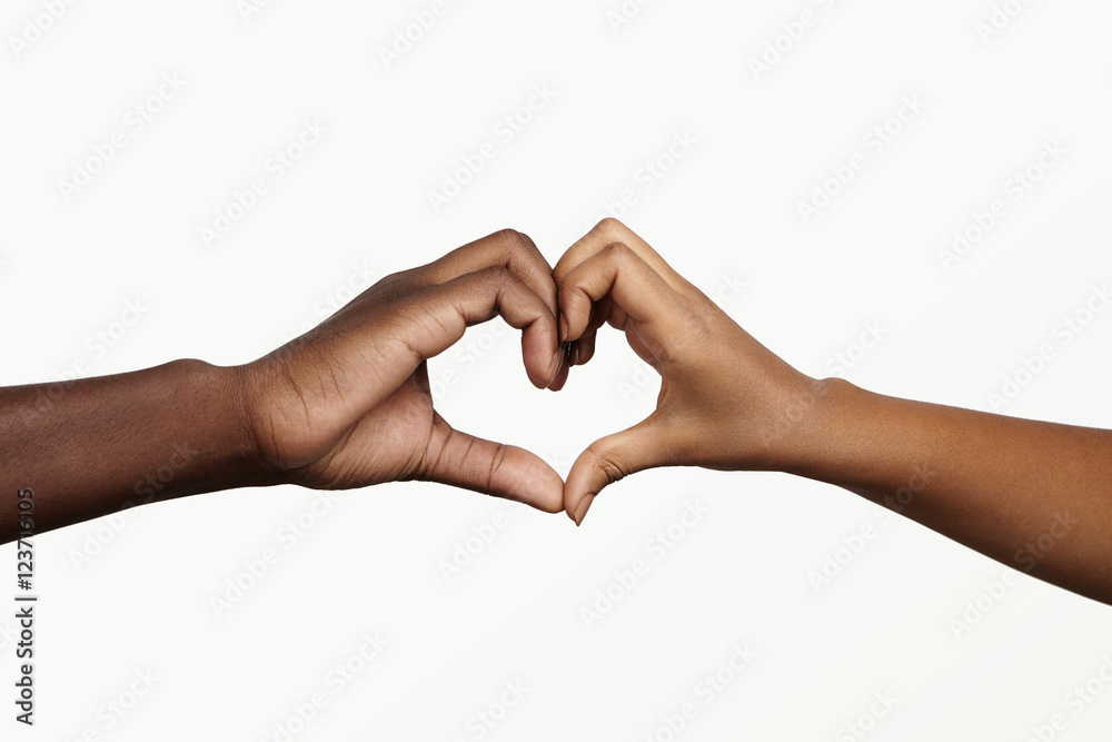 Two young dark-skinned people holding hands in shape of heart ...