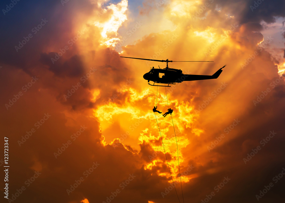 silhouette soldiers in action rappelling climb down from helicopter ...