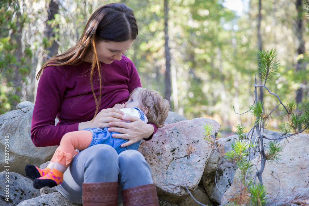 Young mother breastfeeding her baby outdoors Stock Photo | Adobe Stock