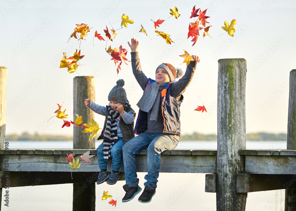 lachende Kinder werfen buntes Laub in die Luft, Spaß im Herbst Stock ...