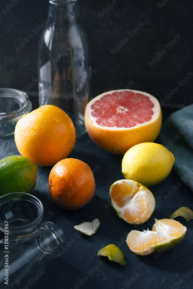 Citrus mix with empty glass bottle on the dark stone background Stock ...