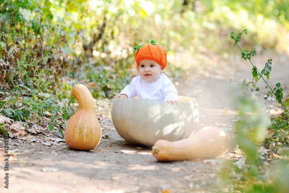 child celebrating Halloween in the middle of autumn forest. Girl sits ...