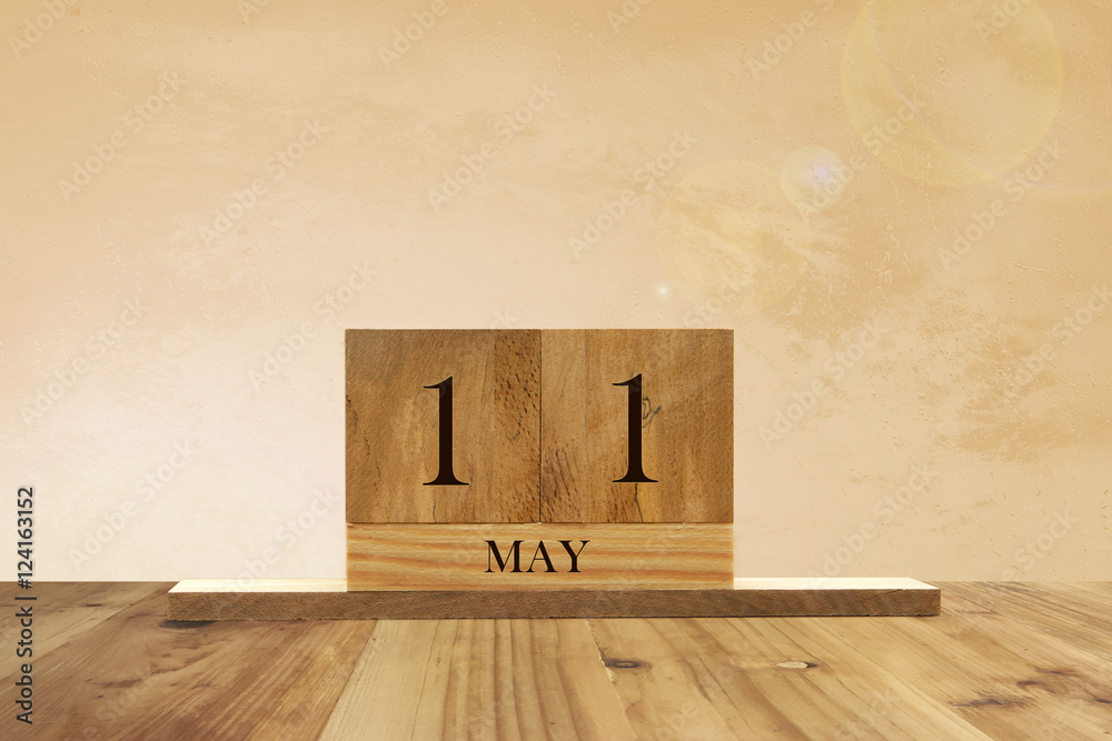 Cube shape calendar for May 11 on wooden surface with empty space for ...