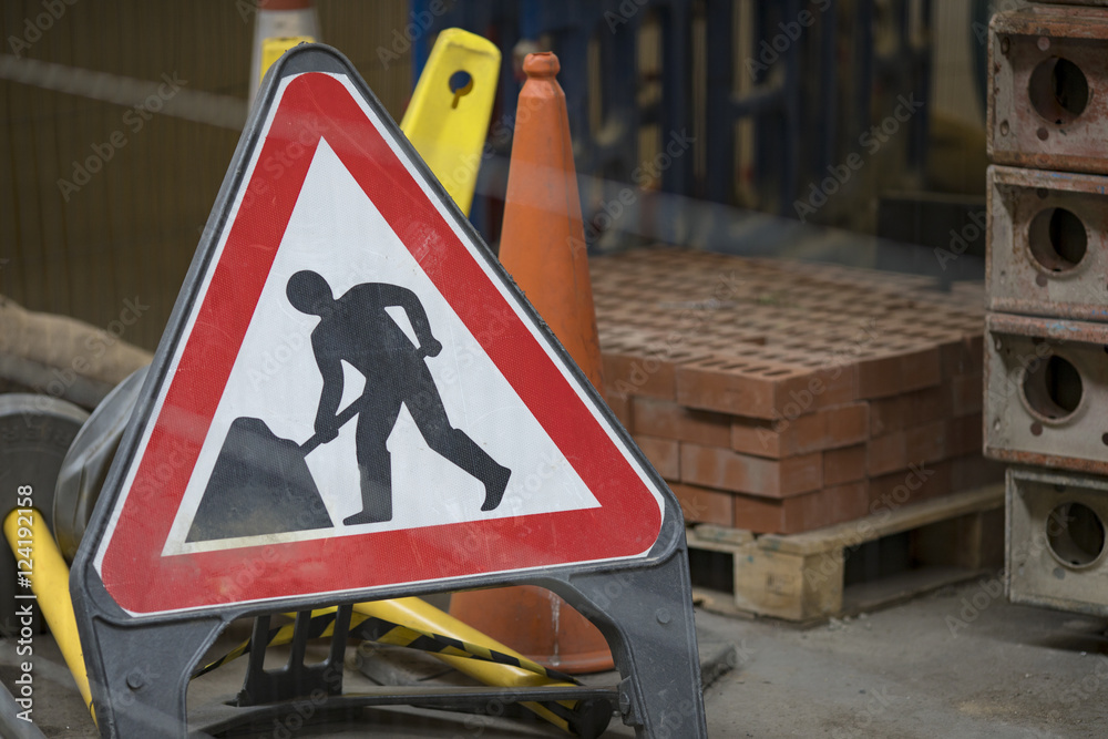 Foto Stock Workman sign amidst a load of building material | Adobe Stock