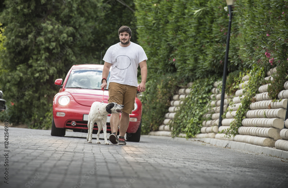 Hombre joven paseando a su perro Stock Photo | Adobe Stock