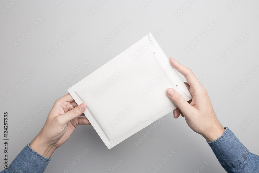 Hand holding blank padded envelope Stock Photo | Adobe Stock