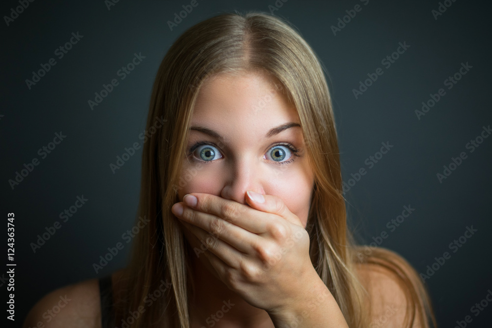 Überraschte Frau hält sich die Hand vor dem Mund Stock-Foto | Adobe Stock