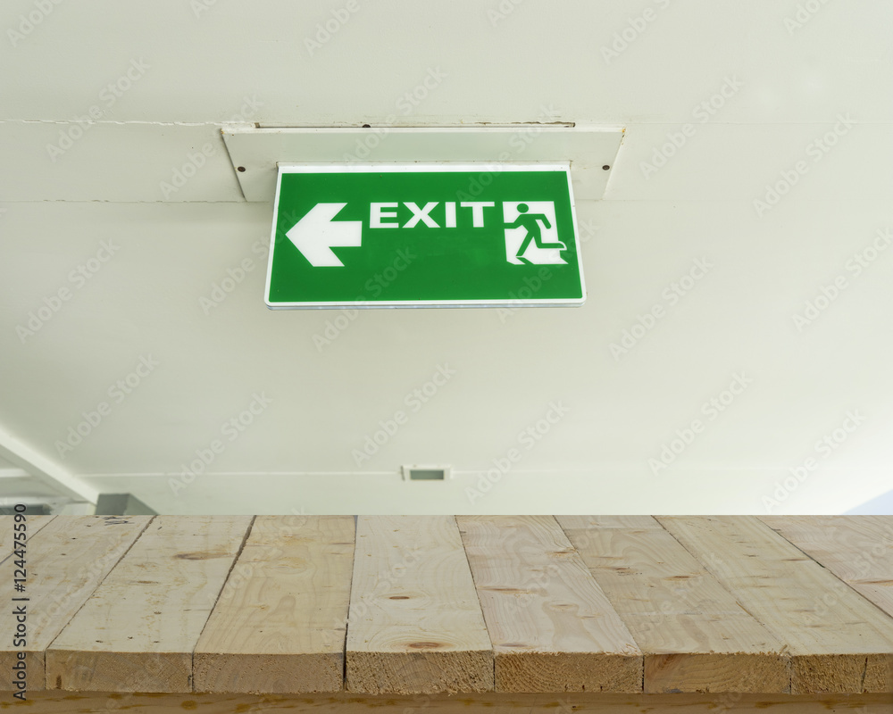 wood table top of fire exit sign on white old ceiling Stock Photo ...
