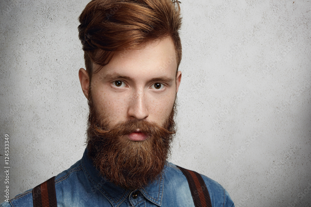 Casual young bearded man with stylish haircut and freckles posing ...