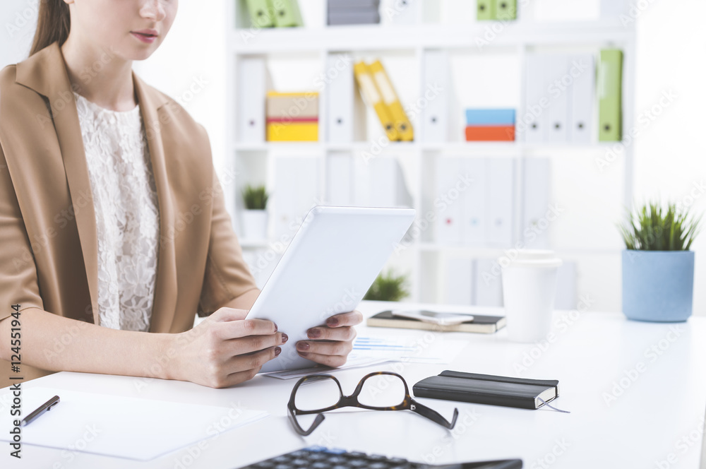 Serious girl looking at tablet computer screen in office Stock Photo ...
