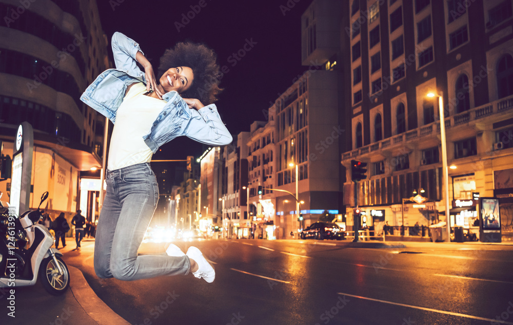 Beautiful young black woman jumping in a city street at night Stock ...