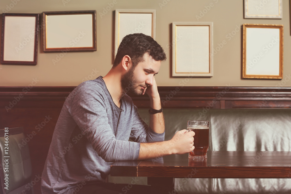 Lonely sad man drinking beer in pub Stock Photo | Adobe Stock