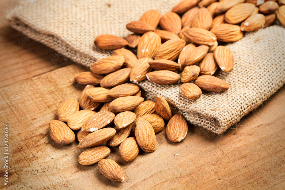 Almendras sobre tabla de madera rústica y saco de arpillera. Vista ...