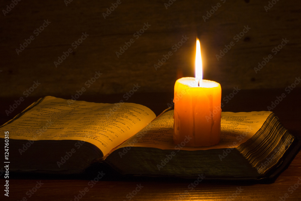 yello candle light on open bible in the night, conceptual image Stock ...