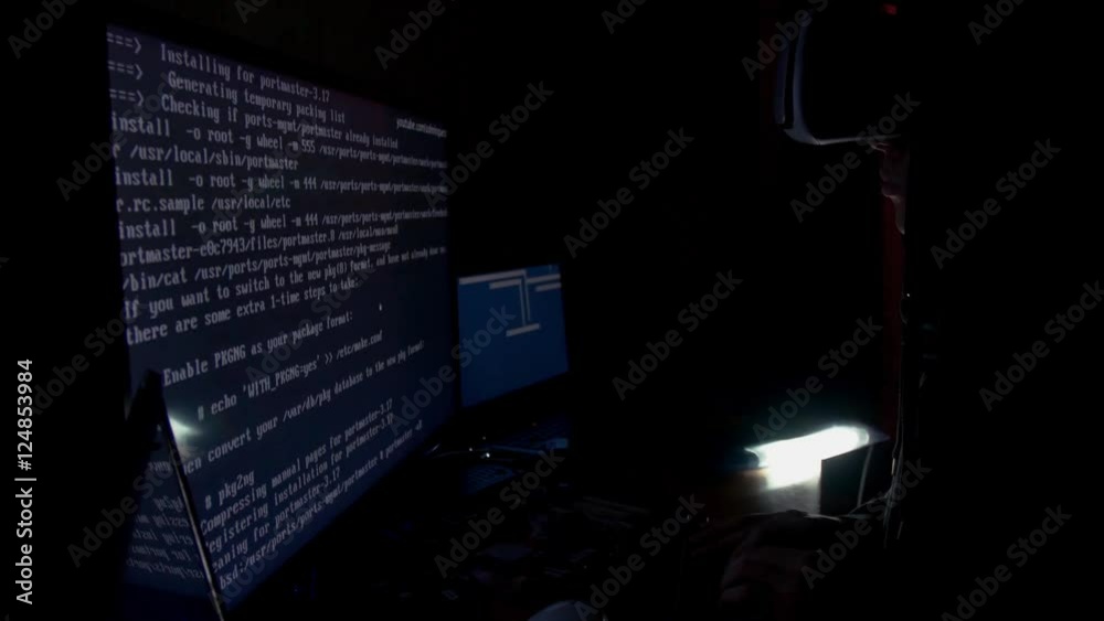 Hacker in hood cracking code using computers in dark room Stock Video | Adobe Stock