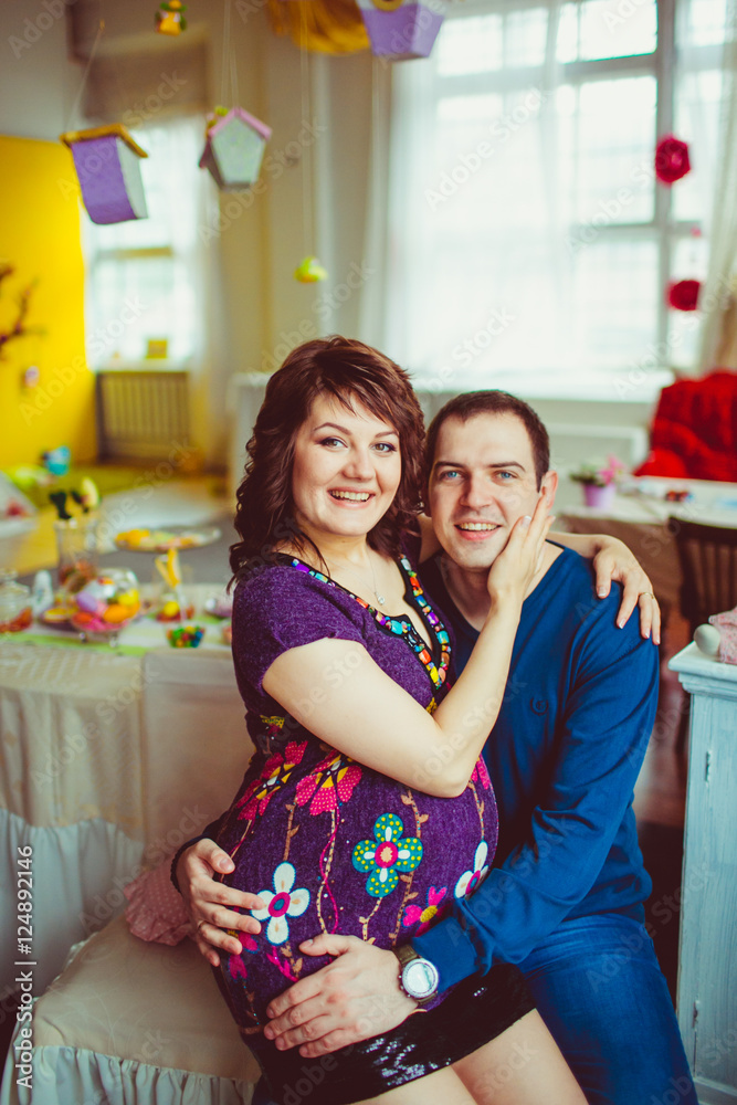 Sweet expecting woman strokes her man's face while sitting on hi Stock ...