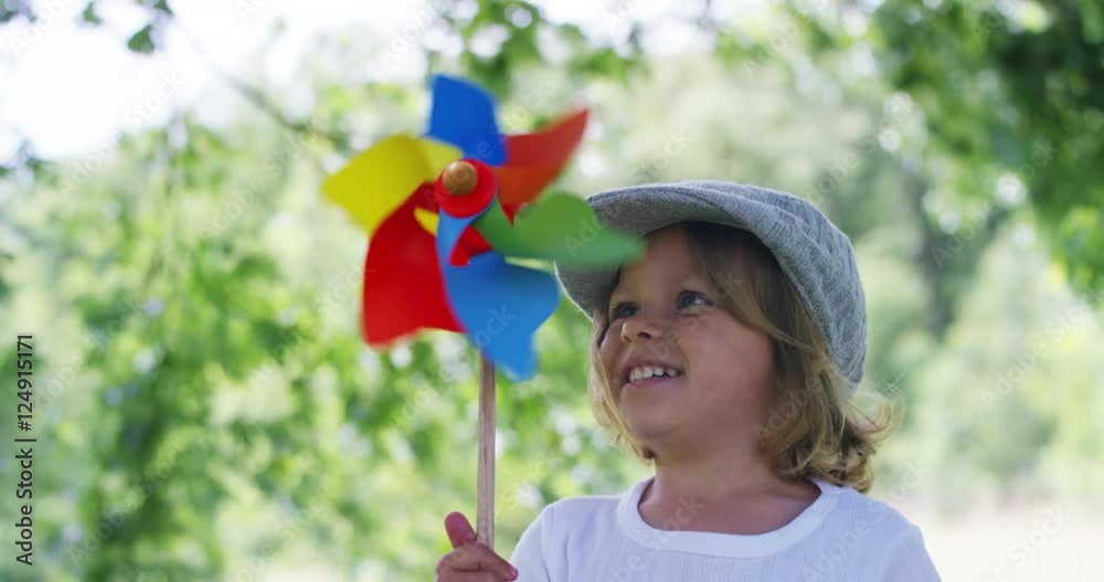 in a day of sun and wind, a happy little beautiful girl in green nature ...