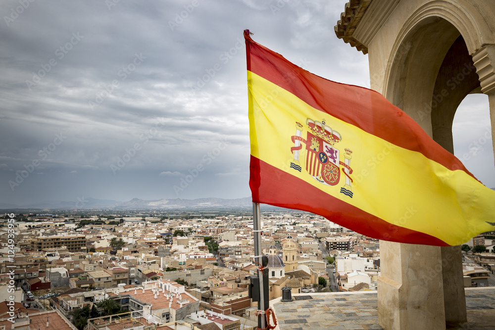 Spanish flag fluttering over Cox town, Alicante, Spain Stock Photo ...