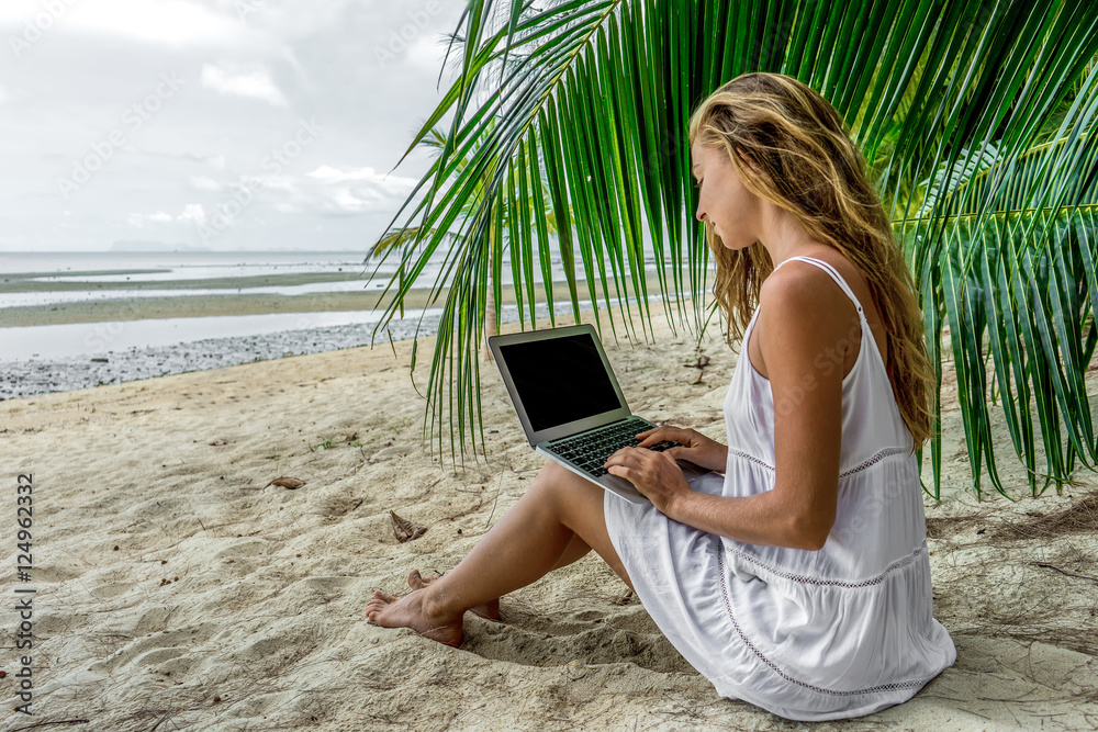 The beautiful girl from computers on the beach, in a white dress with ...