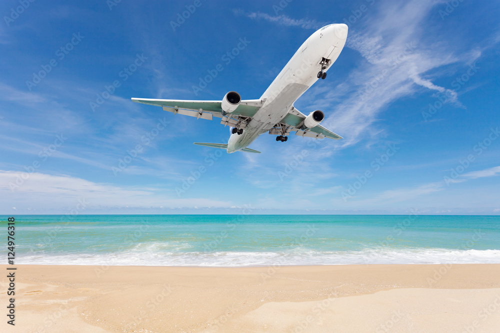 Airplane landing above beautiful beach and sea background. Stock Photo ...