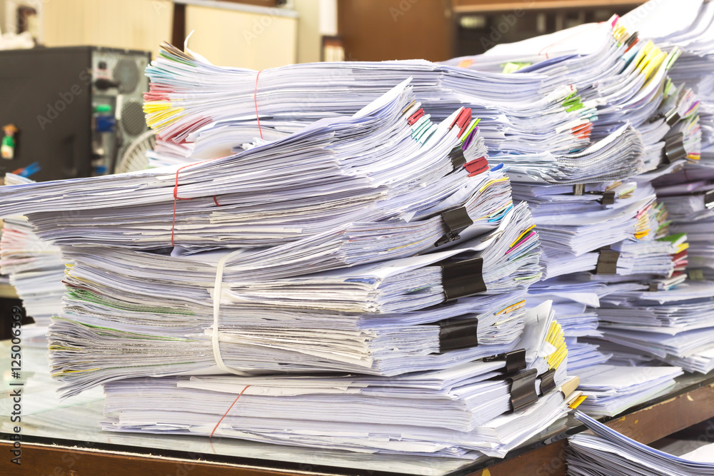 Pile of documents on desk stack up high waiting to be managed Stock ...