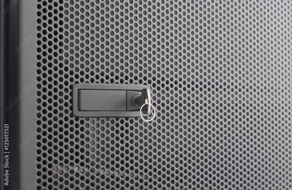 Door perforated of server rack cabinet. The key is inserted into the ...