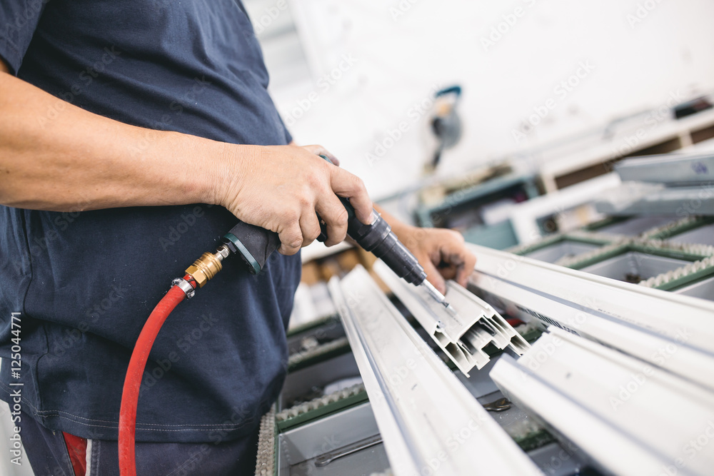 Manual worker assembling PVC doors and windows. Manufacturing jobs ...