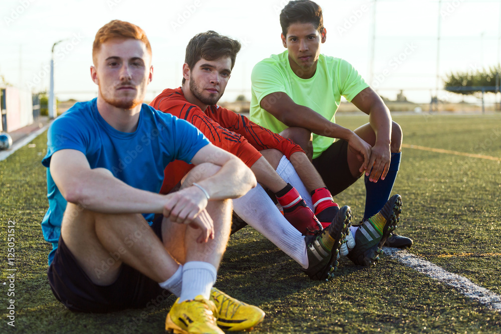 Portrait of soccer players sitting on soccer pitch Stock Photo | Adobe ...