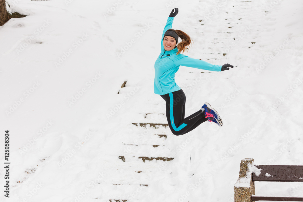 Young girl jumping on the snow. Stock Photo | Adobe Stock