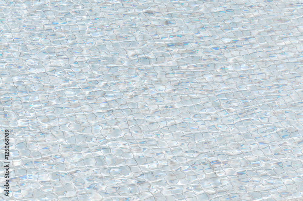 Pool water with waves and reflections of the floor tiles on water ...
