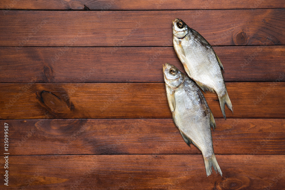 two dried fish on a light brown wooden background with empty spa Stock ...
