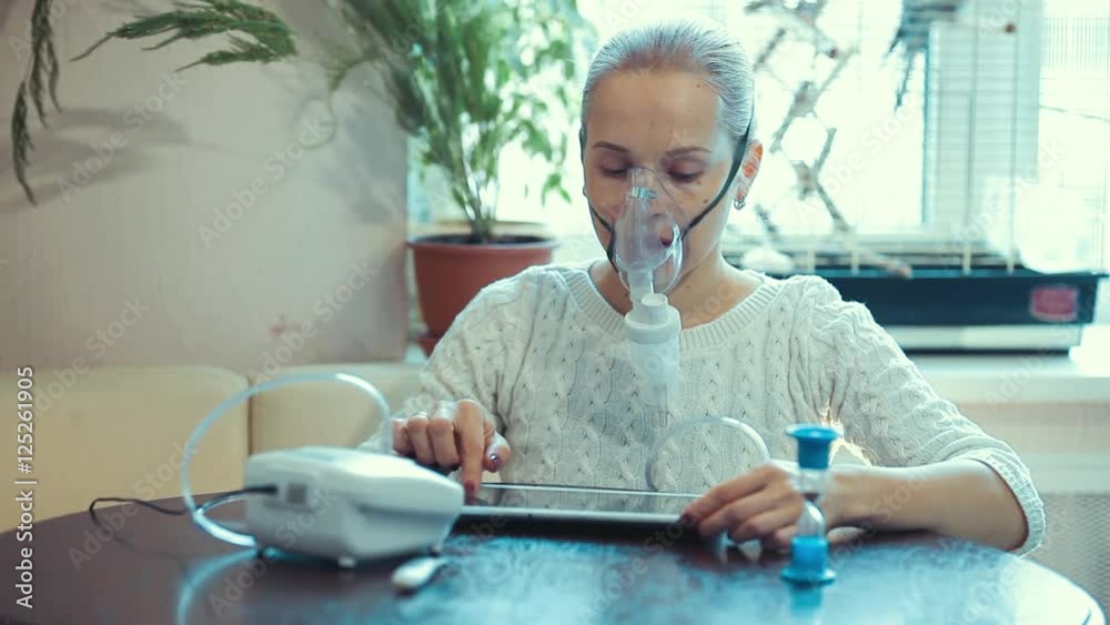 Girl with asthma problems making inhalation with mask on her face ...