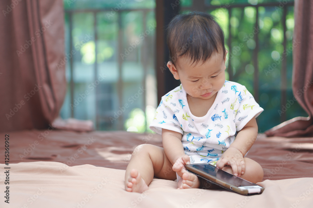 Asian baby playing mobile phone Stock Photo | Adobe Stock