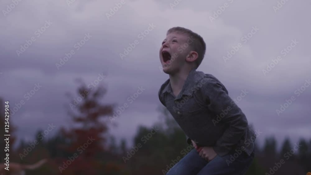 A young boy catching a ball hurts his finger and yells and his father ...