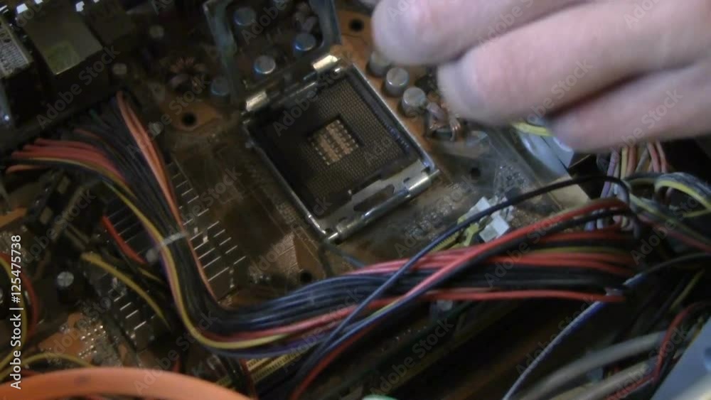 installation of CPU/Man hands assembling processor on the motherboard ...