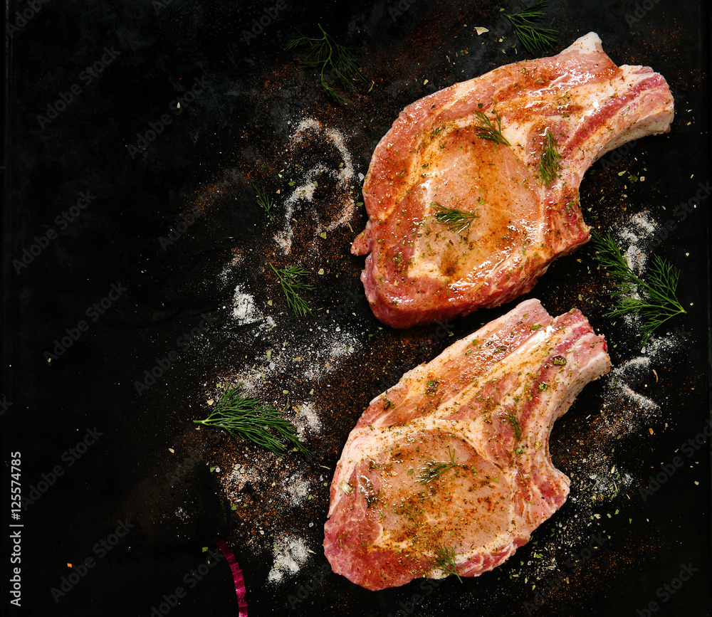 Raw pork chops with spices on a black background, top view, flat photo ...