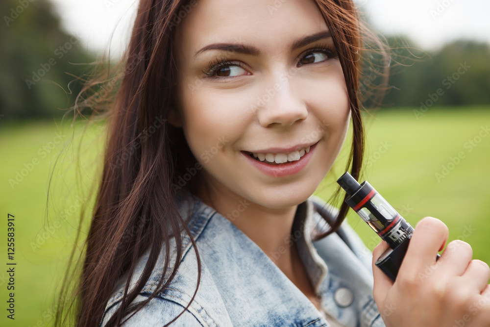 Young girl vaping.Portrait of beautifiul brunette female model smoking ...