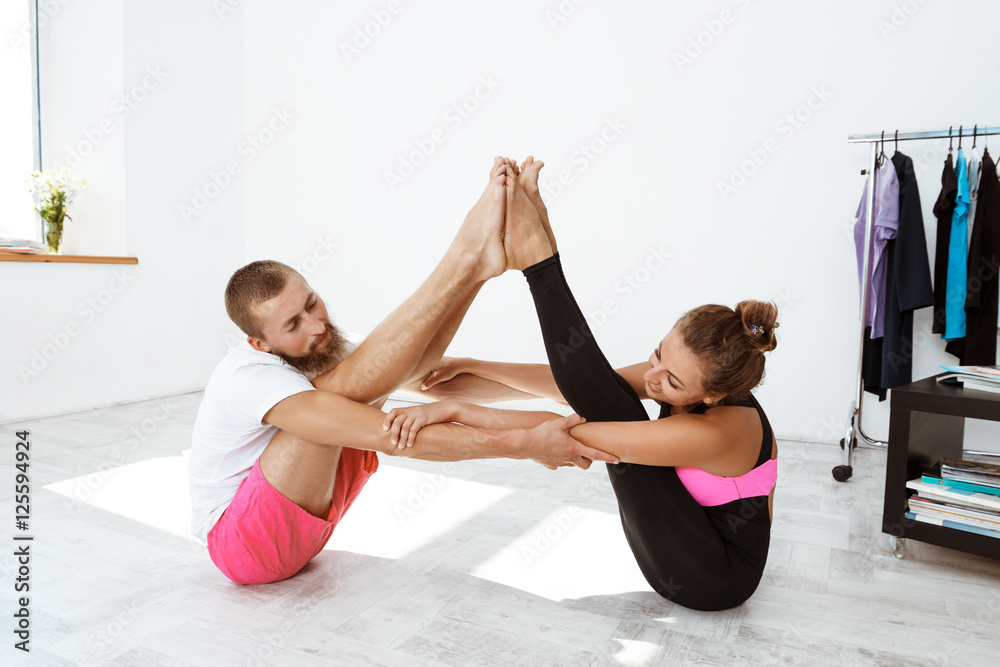 Young beautiful sportive couple practicing yoga asanas at home ...
