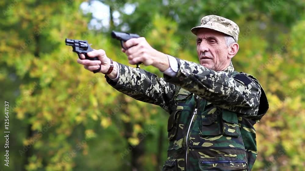 Video Stock Soldier in military uniform shoots a revolver. Retired ...