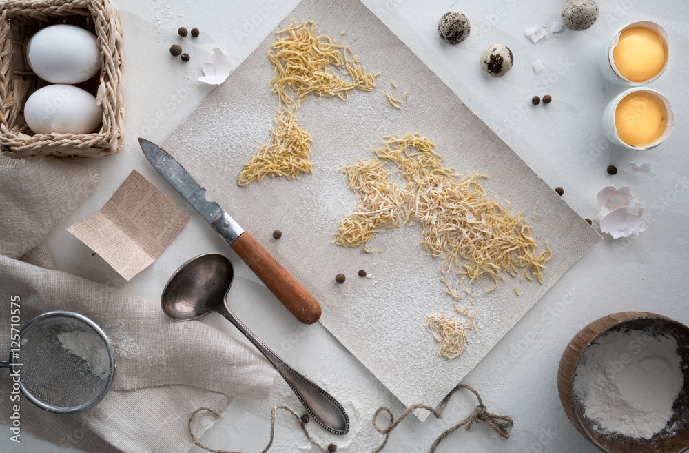 map of the world pasta on the canvas. flour sieve spices. food, top ...