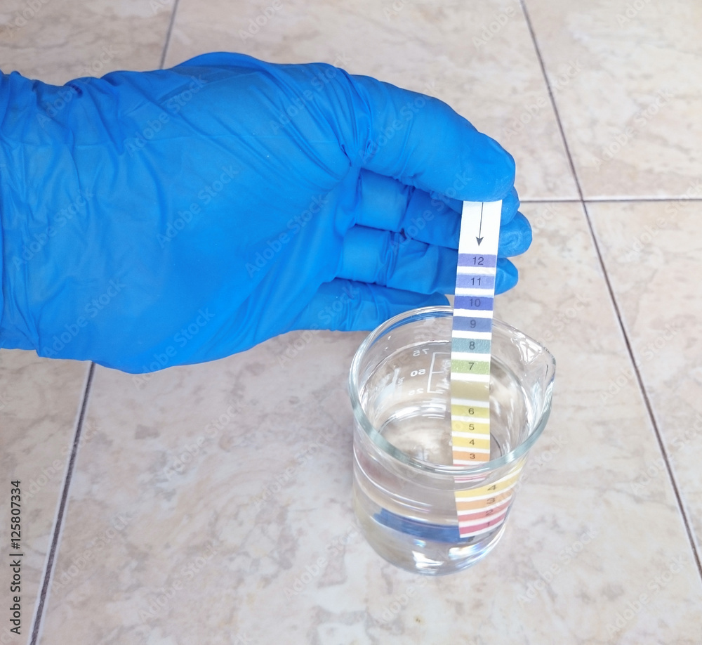 pH test of water solution in chemical glassware by color strip Stock ...