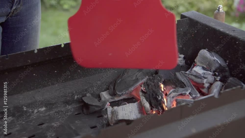 The man makes fire for a barbecue. The man makes a dinner. The person ...