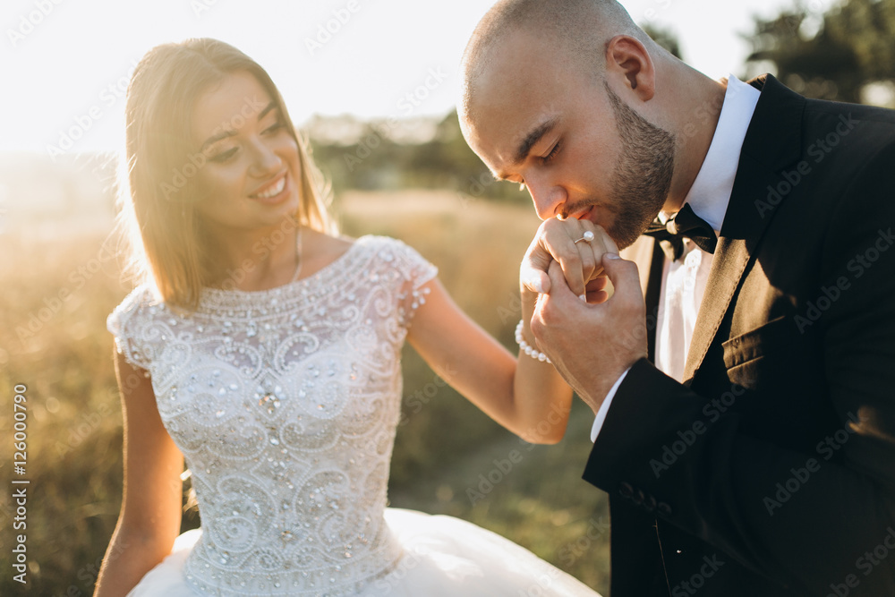 Foto Stock Stylish bride and bearded muscular groom posing on the ...