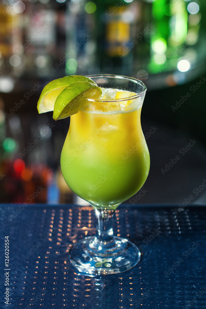 bright yellow-green cocktail garnished with lime. Classic alcohol ...