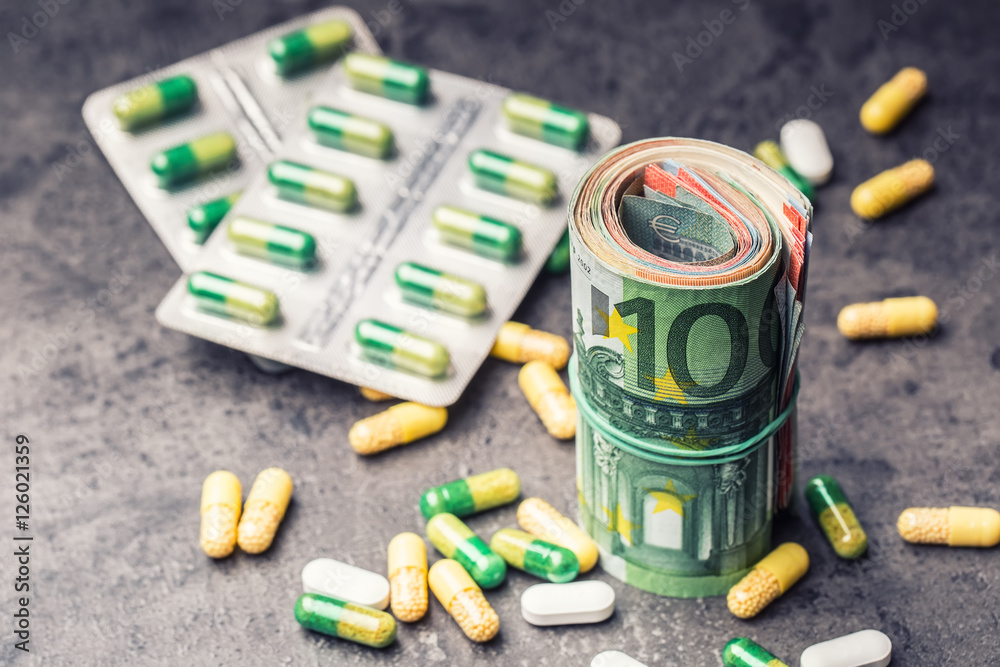 Euro money and medicaments. Euro coins and pills. Rolled euro banknotes ...