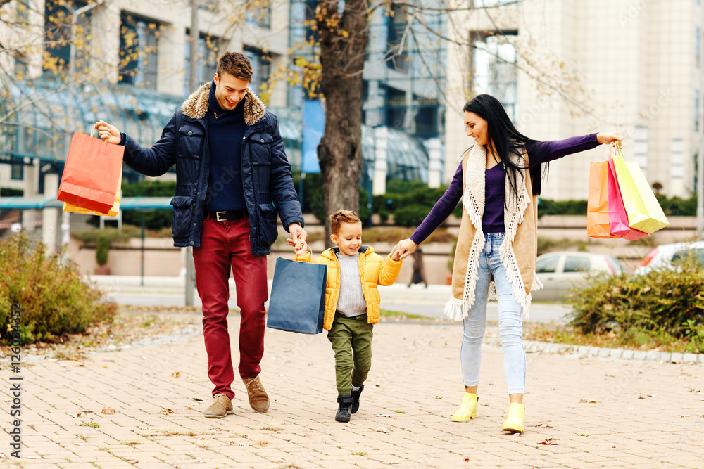 Young happy family walking down the street after shopping Stock Photo ...