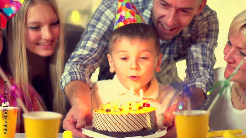 Little boy blows out candles on birthday cake at party, Happy big ...