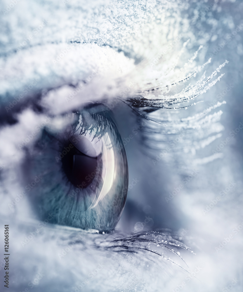 Open expressive blue eyes with frost or snow on eyelashes macro close ...