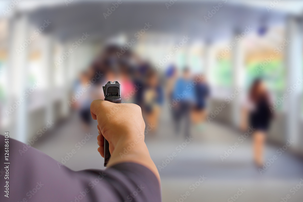 Man holding gun against and crowd background Stock Photo | Adobe Stock